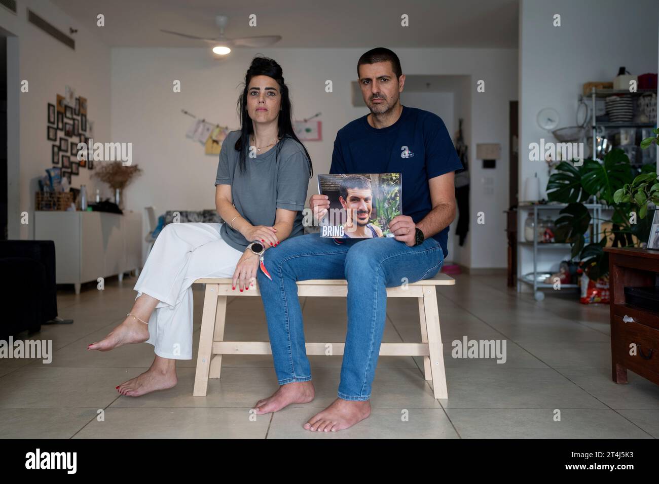 Hila Levy, sitting beside her husband Michael, holds up a portrait of his brother, 33-year-old ...