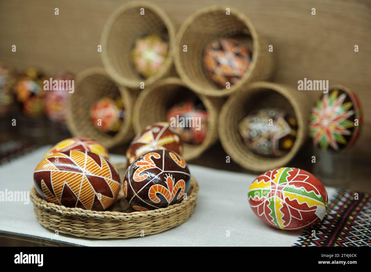 Colorful hand painted Easter Eggs in a wicker bowl. Egg decorating in ...