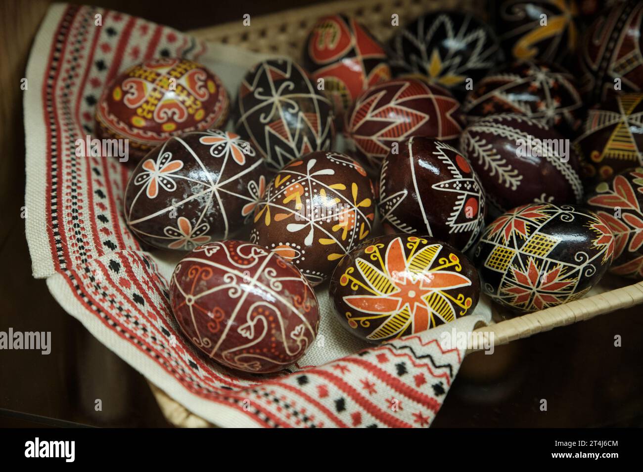 Colorful hand painted Easter Eggs in a wicker bowl. Egg decorating in ...
