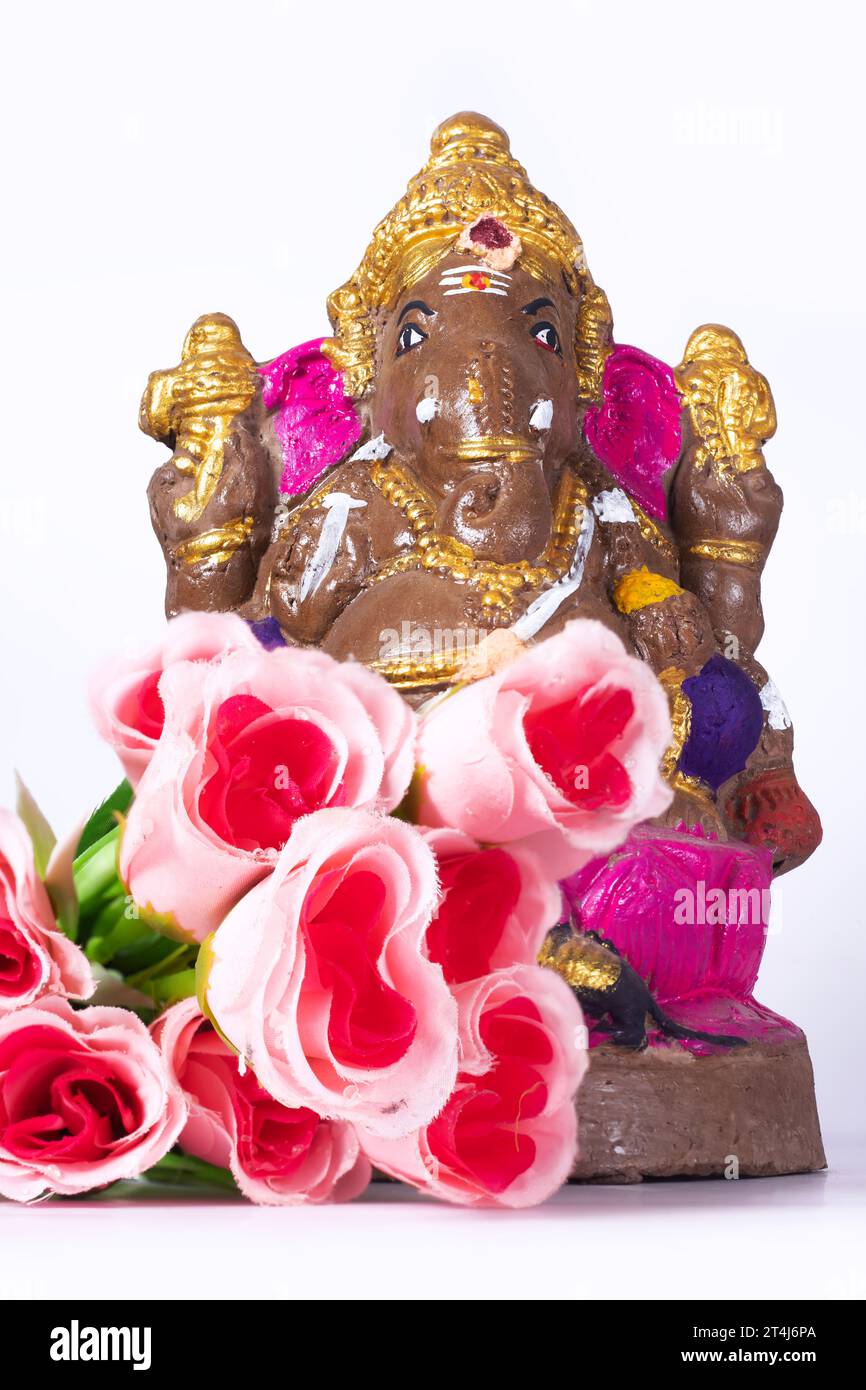 Ganesh statue made of clay is also a rose flower on white background ...