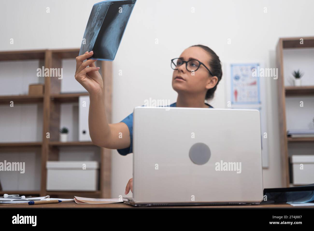 female doctor scrutinizes patient X-ray scan, concurrently checking ...