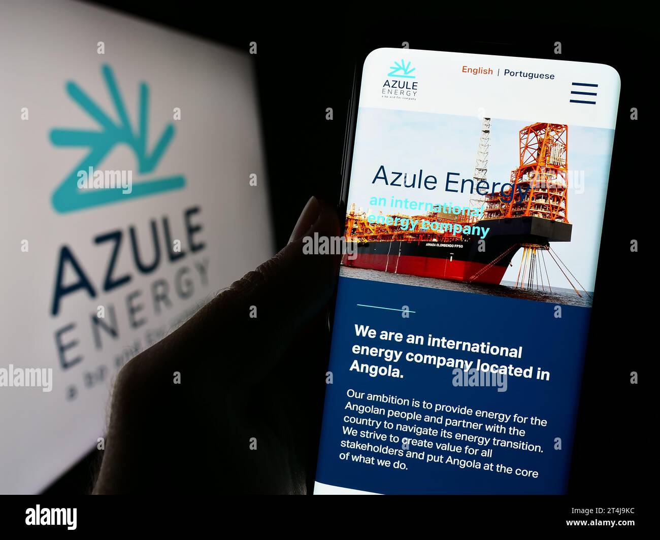 Person holding cellphone with webpage of Angolan oil company Azule ...