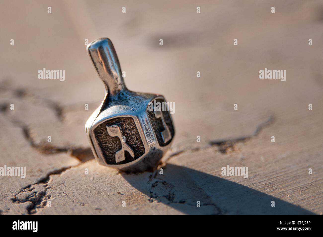 Small, silver cast silver Hanukkah dreidel, a top used to play a game ...