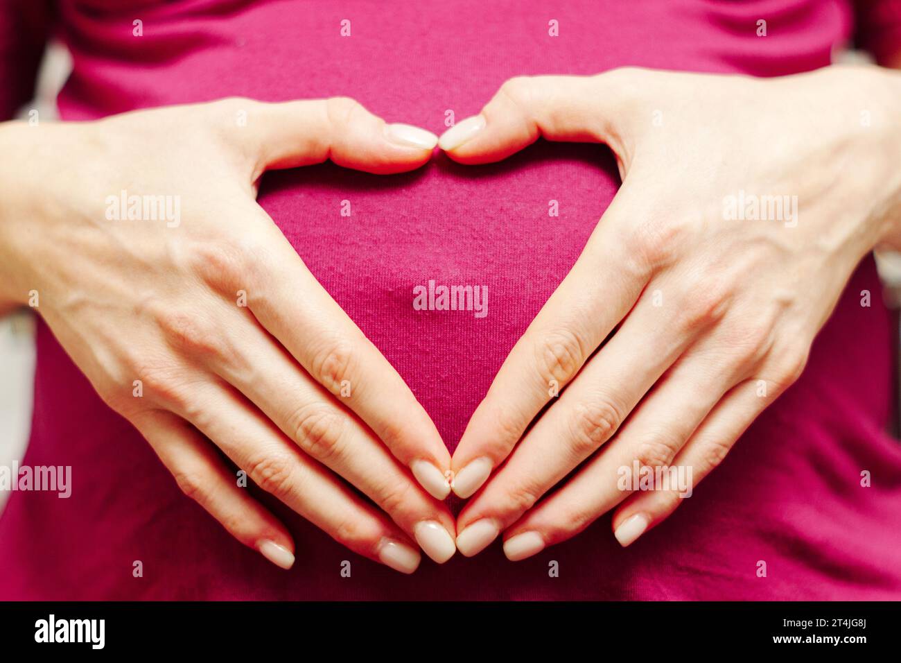 Woman hands made a heart on her stomach. Waiting for a child. The ...