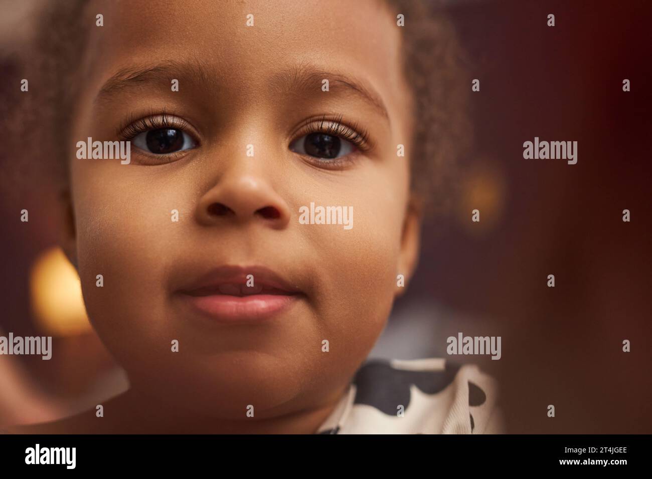 Close up portrait of cute Black little girl with big eyes looking at ...