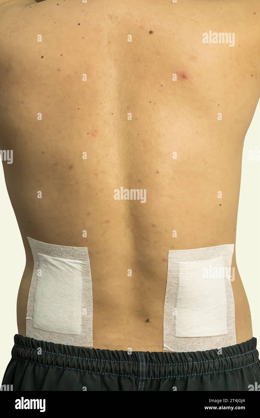 Pain relief patch on men's lumbar region Stock Photo - Alamy