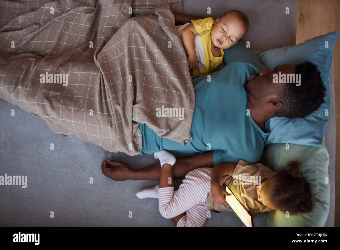 Top down view of exhausted African American man sleeping with two ...