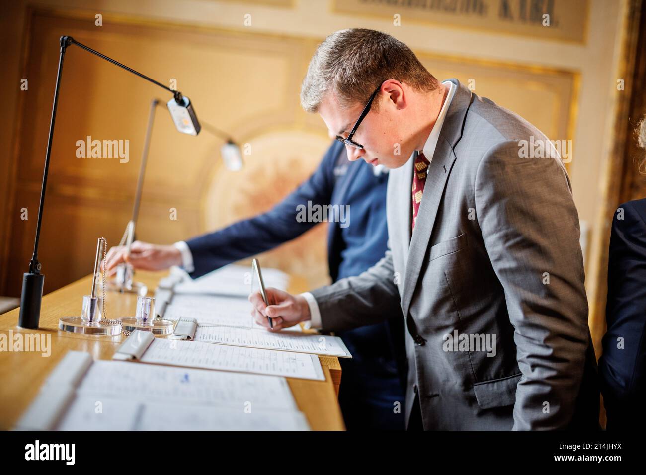 31 October 2023, Bavaria, Munich: Daniel Halemba (AfD) signs a list ...