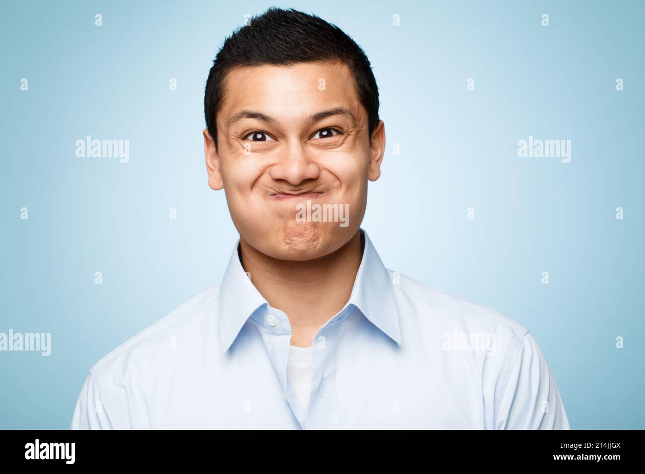 He might just explode. a young man making facial expressions against a ...