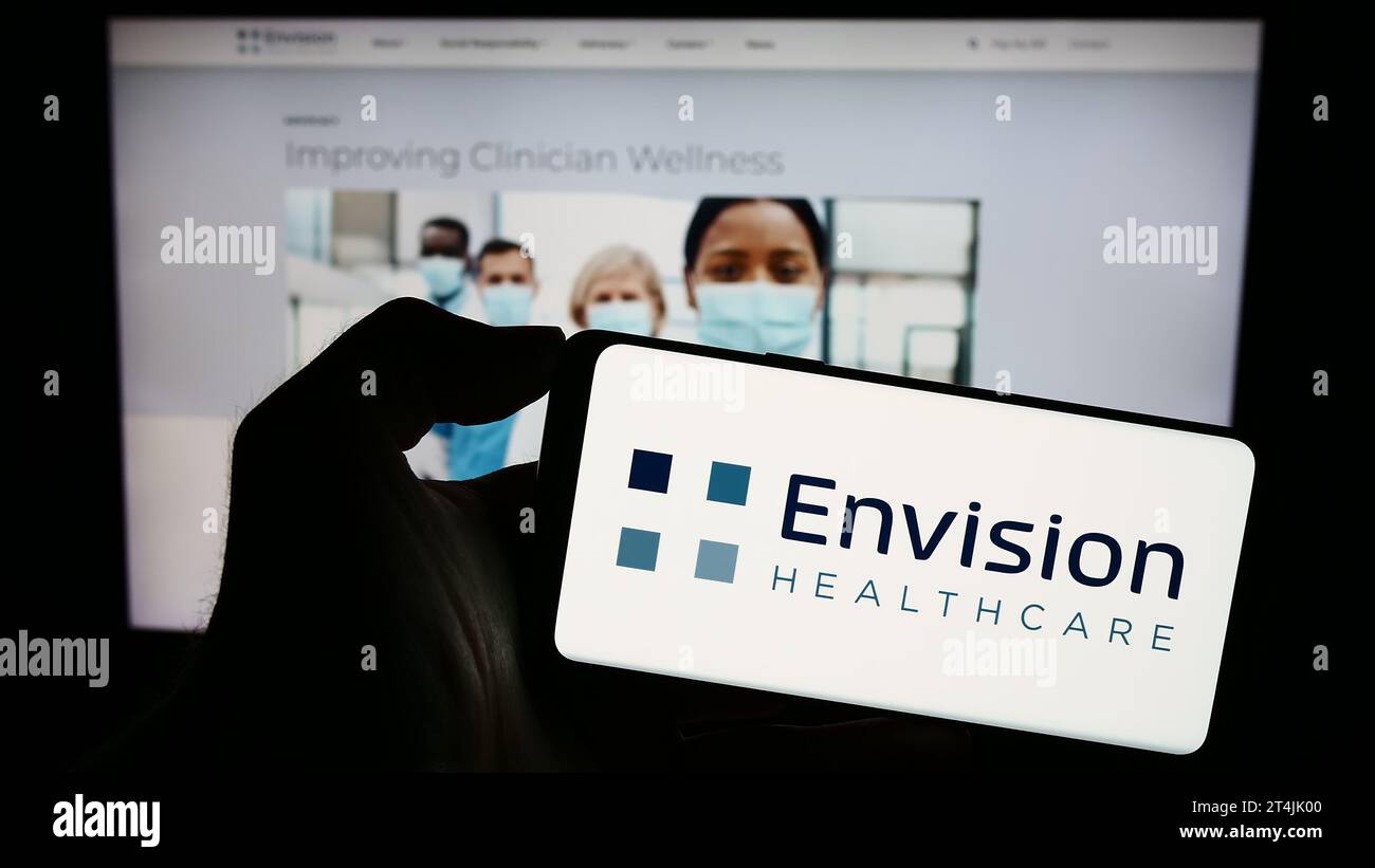 Person holding mobile phone with logo of American hospital company ...