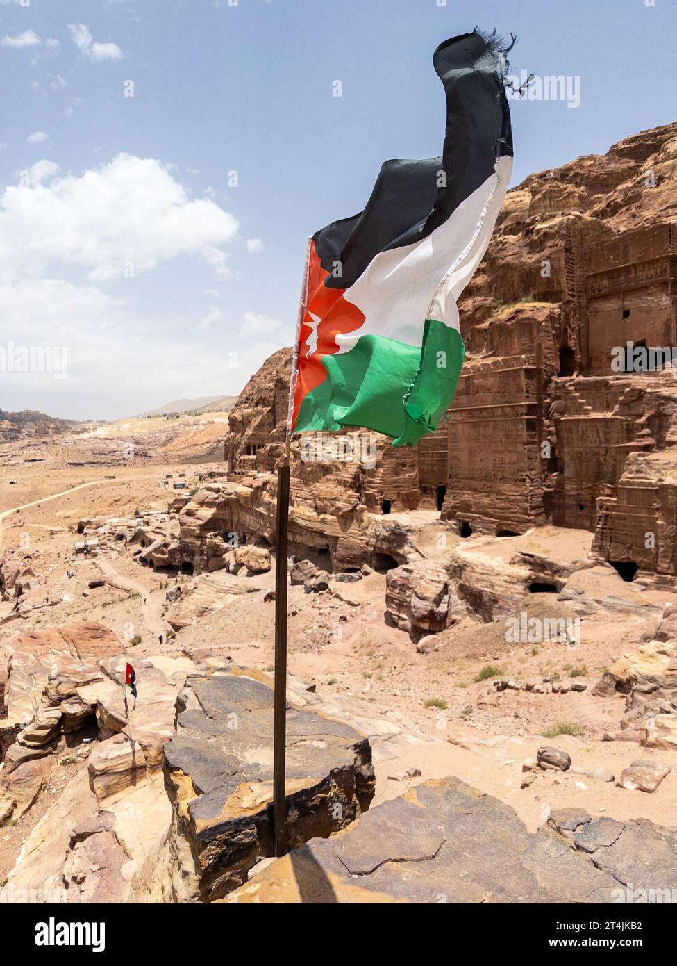 A vertical shot of the Jordanian flag flapping in the wind set atop a ...