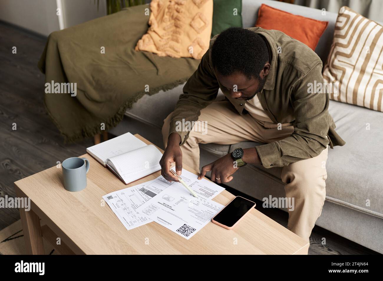 High angle portrait of Black adult man doing taxes at home and filling ...