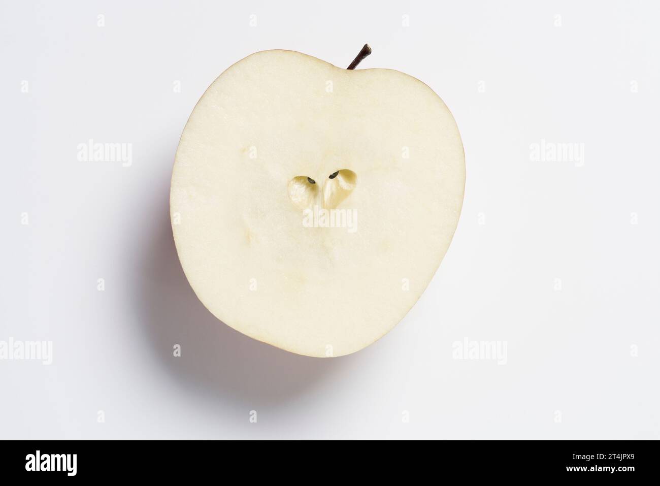 Apple sliced in half on white background, revealing heart shaped core ...