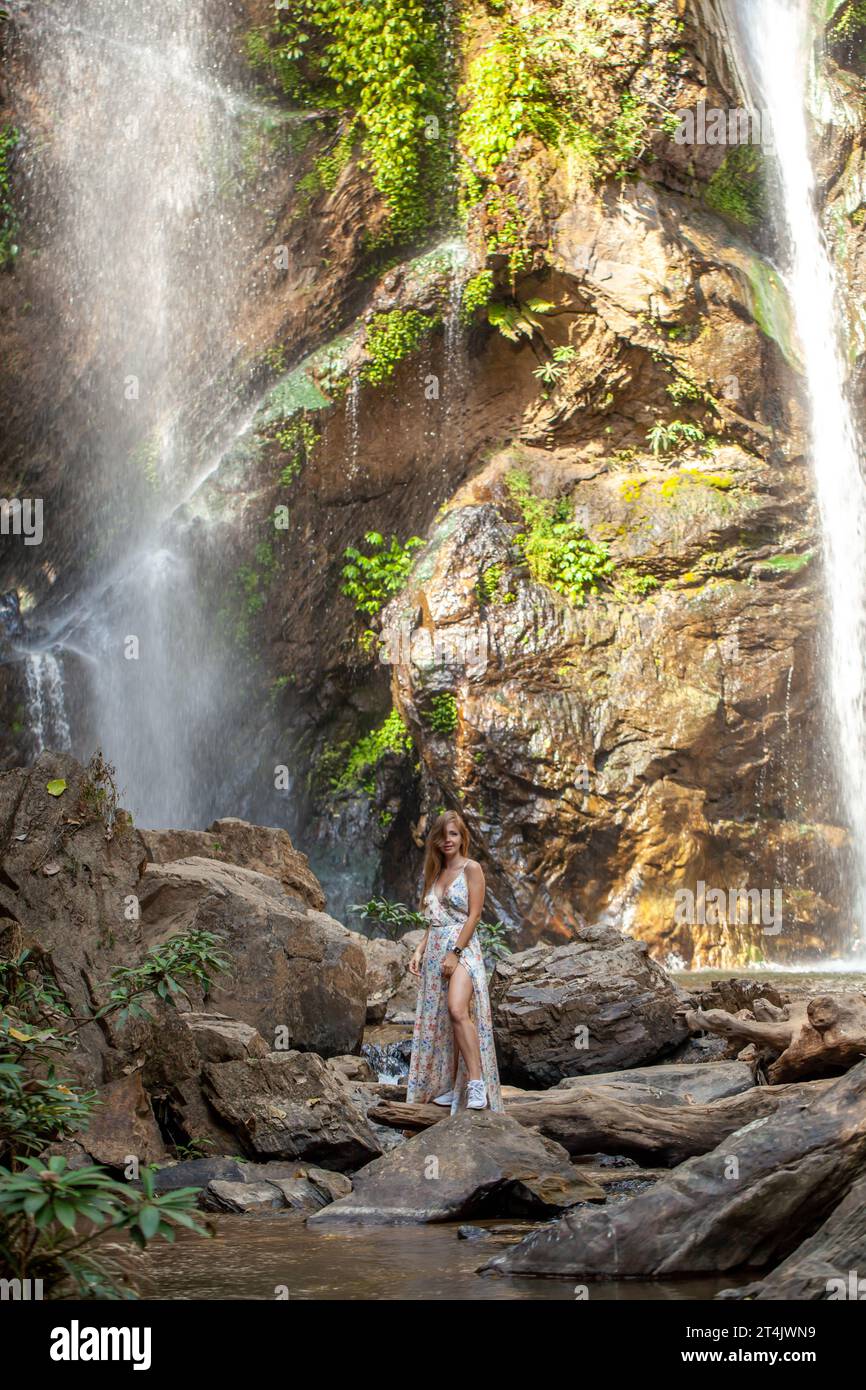 Young woman on rock under massive waterfall in Thailand Stock Photo - Alamy