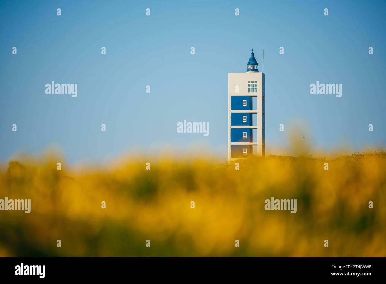 A modern lighthouse stands out in a blurry foreground Stock Photo - Alamy