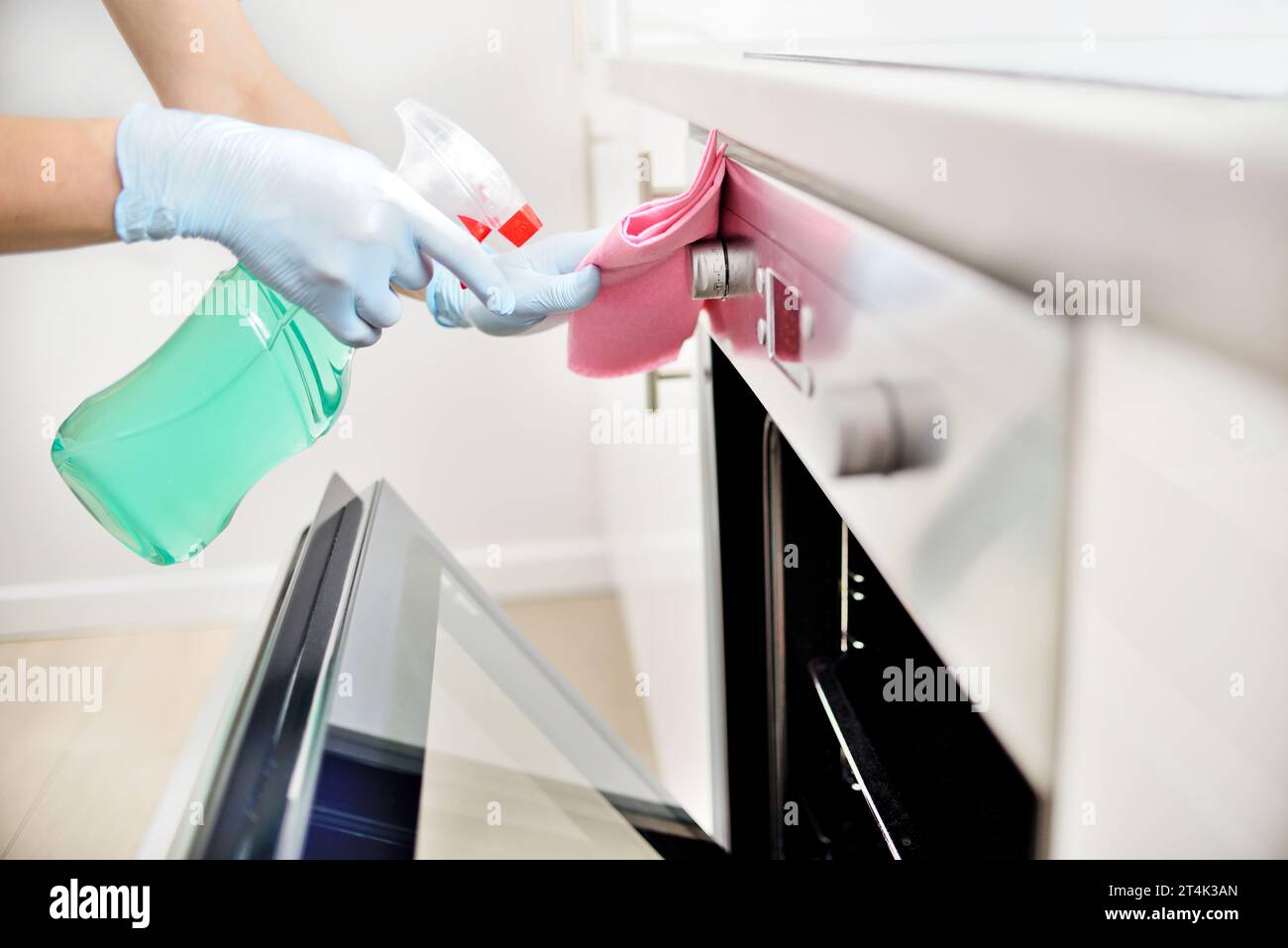 Woman in gloves cleaning kitchen Stock Photo - Alamy