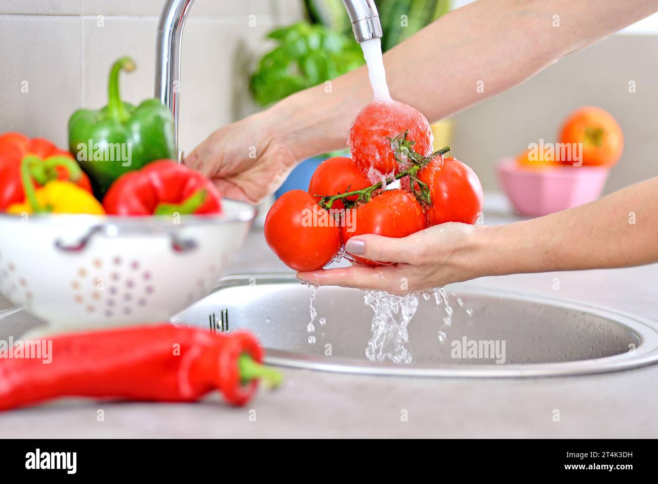 Washing vegetables. A woman in the kitchen Stock Photo - Alamy