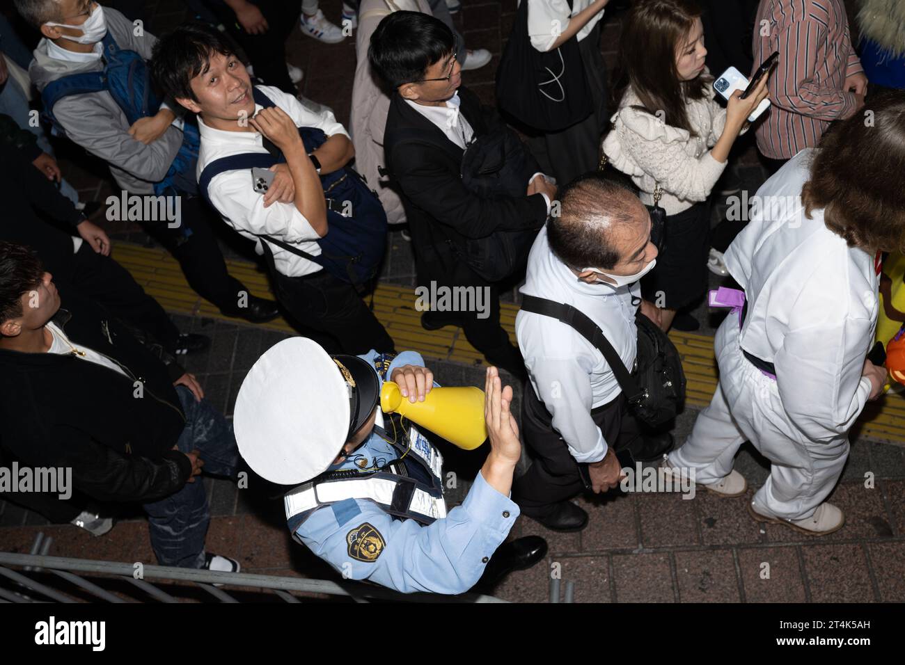 Tokyo, Japan. 31st Oct, 2023. Revelers navigate crowd control barriers ...