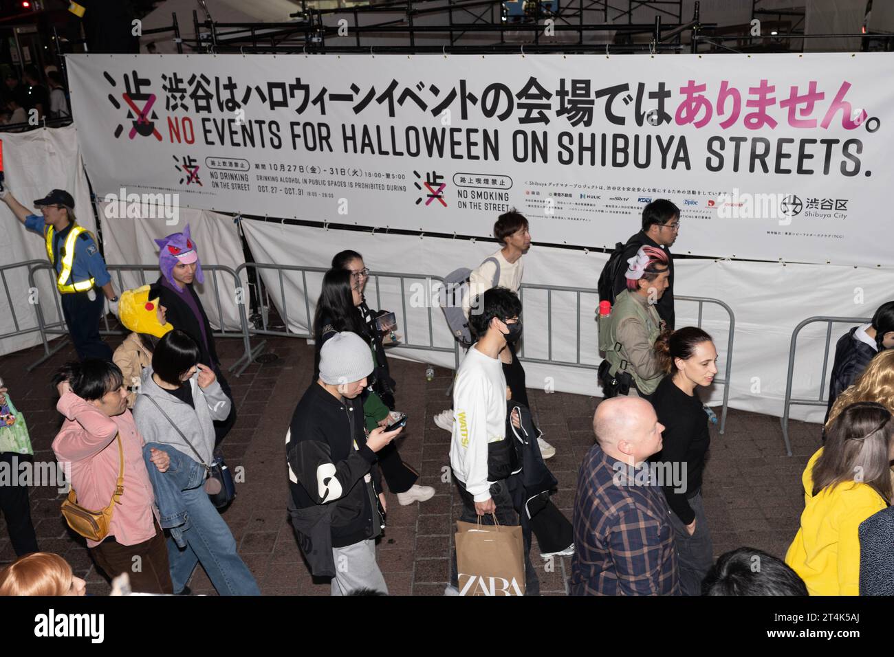 Tokyo, Japan. 31st Oct, 2023. Revelers navigate crowd control barriers ...