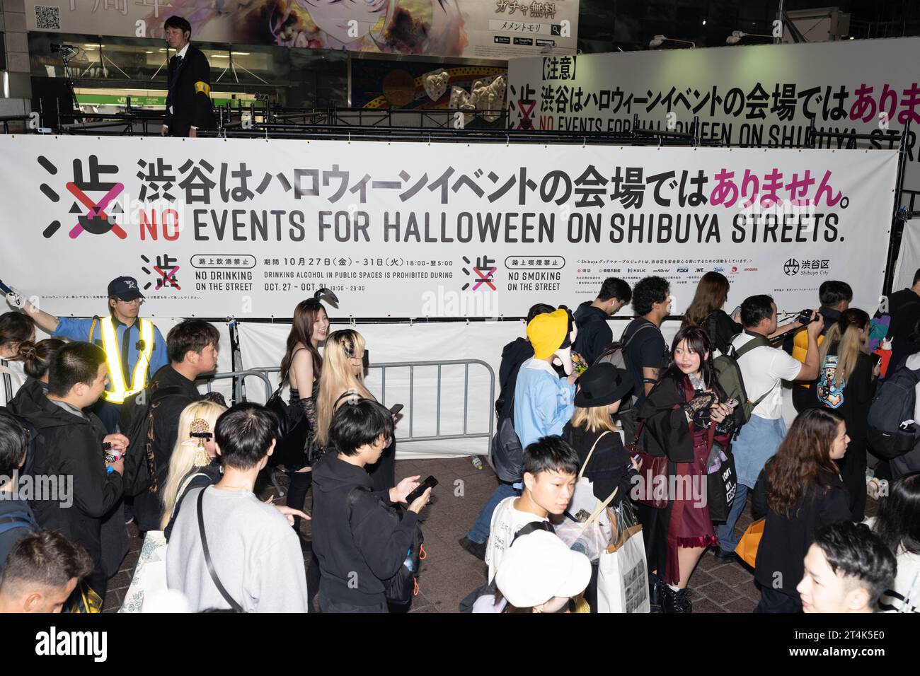 Tokyo, Japan. 31st Oct, 2023. Revelers navigate crowd control barriers ...