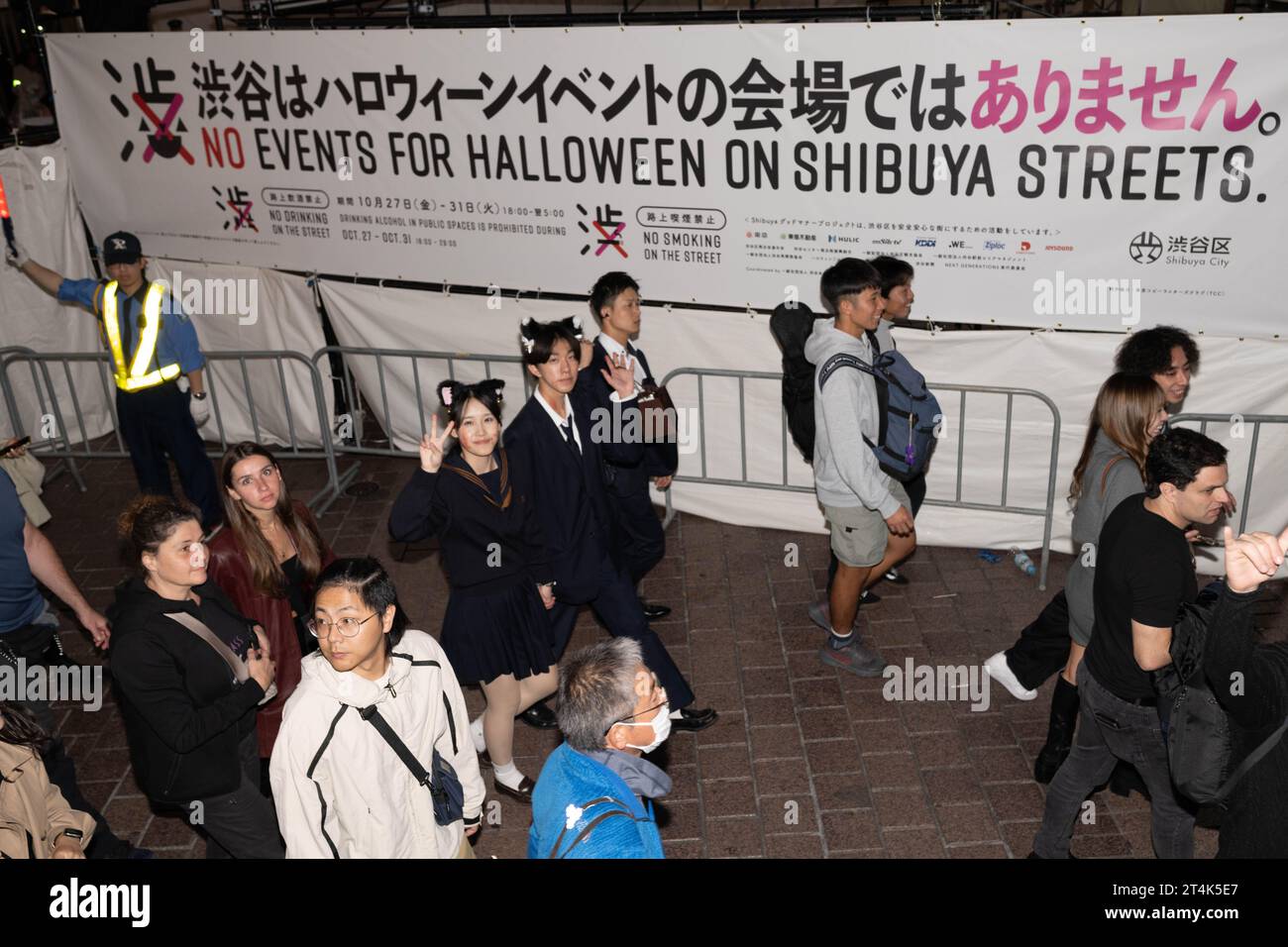 Tokyo, Japan. 31st Oct, 2023. Revelers navigate crowd control barriers ...