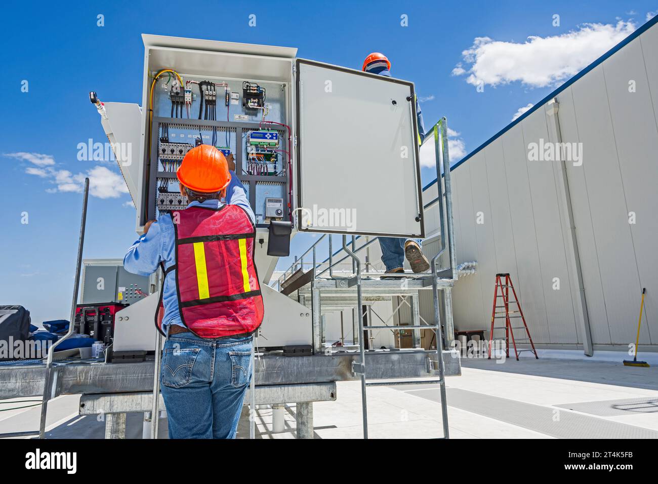 Two construction workers check the control panel of an adiabatic ...