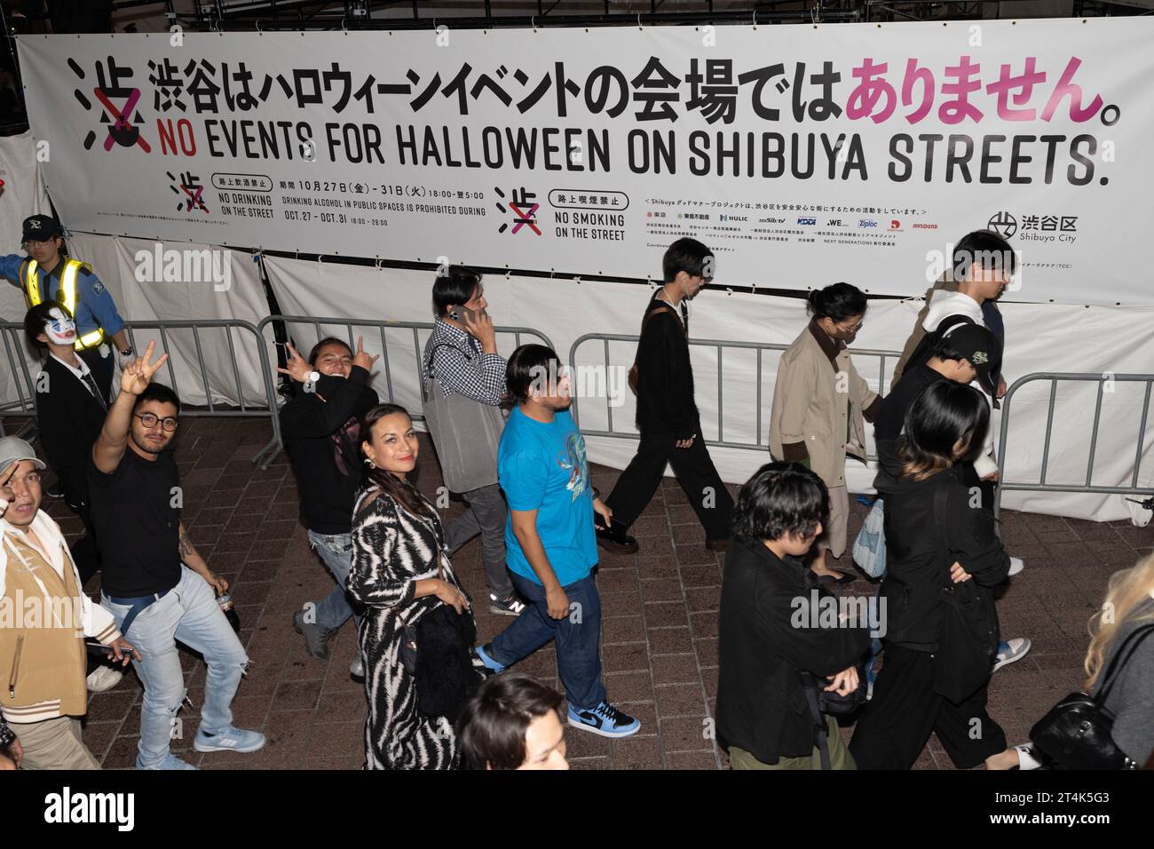 Tokyo, Japan. 31st Oct, 2023. Revelers navigate crowd control barriers ...