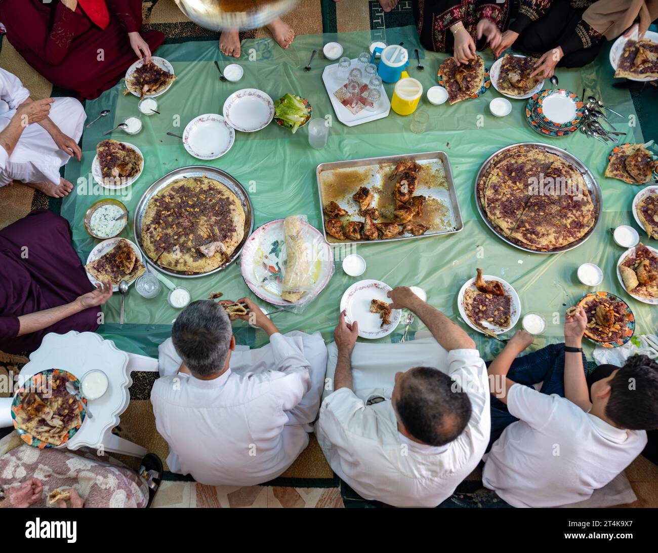 Family and friends gathering together at home for eating musakhan and ...