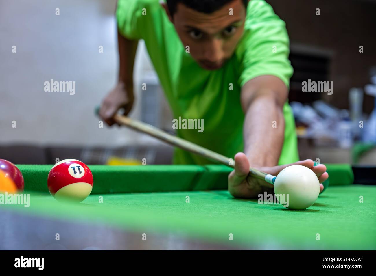 Young adult bearder male playing billiards with his friends focusing on ...