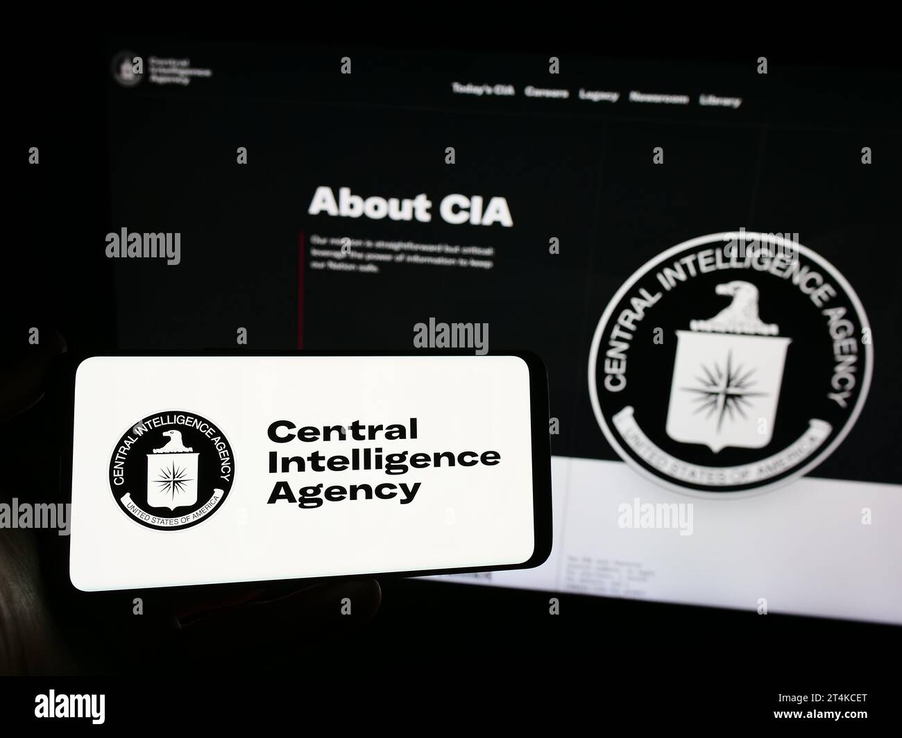 Person holding mobile phone with logo of American Central Intelligence ...
