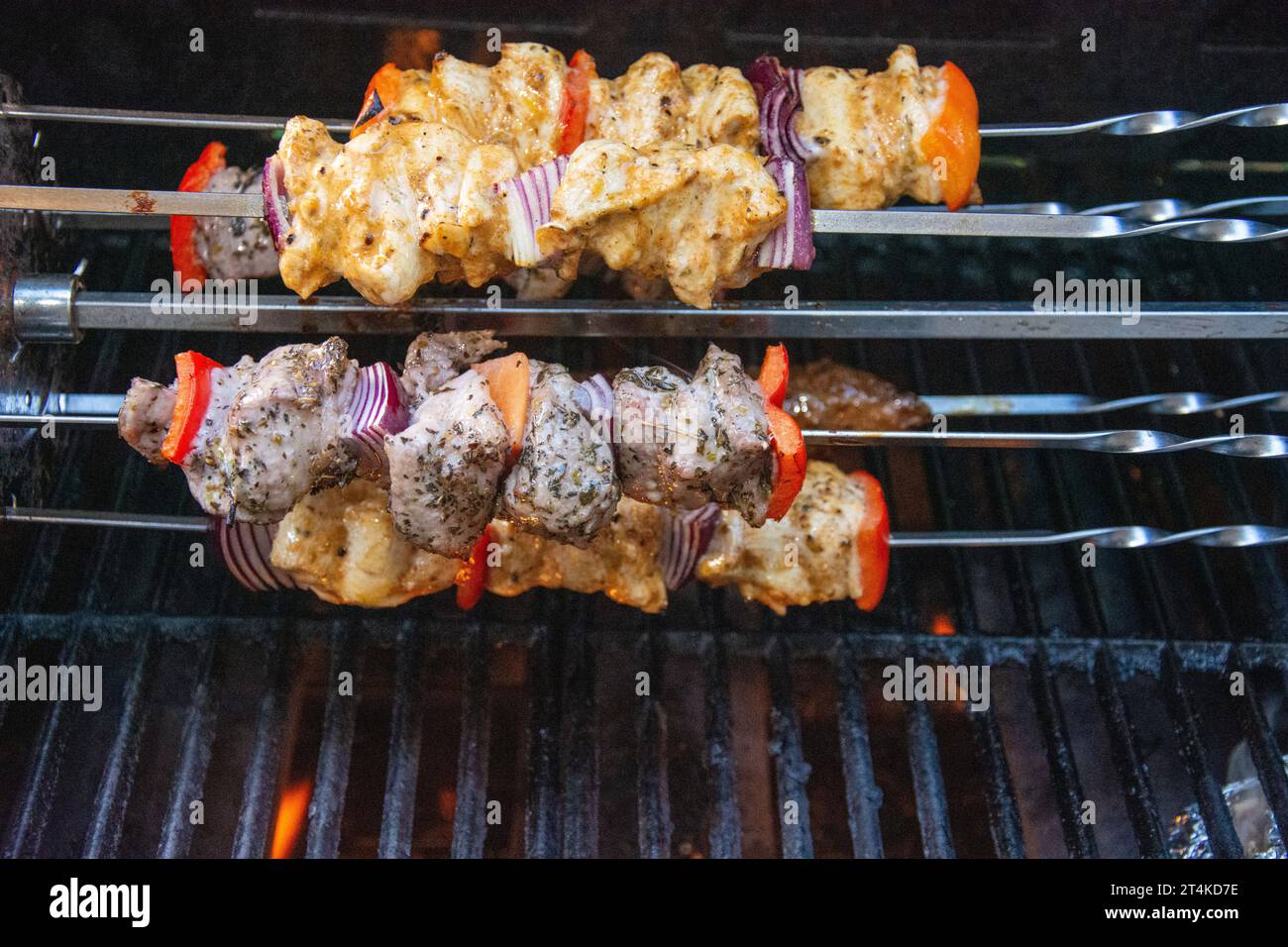 Various meats are barbecued on a rotating rotisserie Stock Photo - Alamy