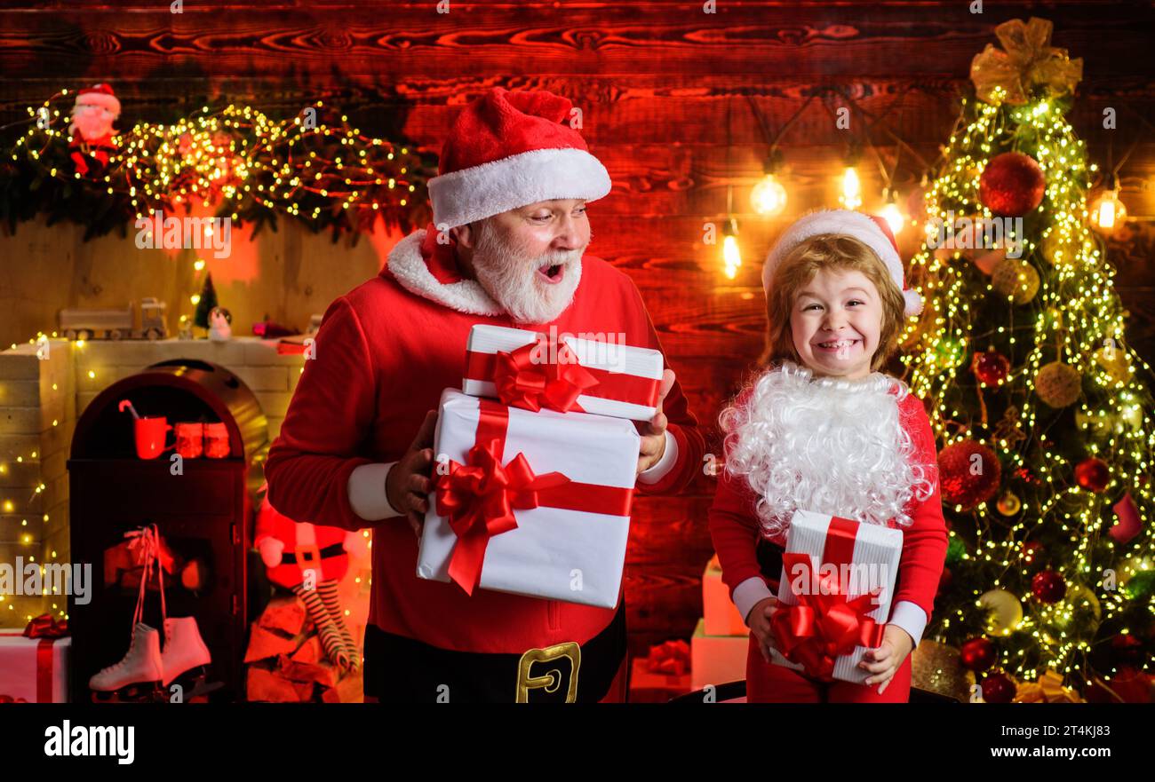 Family holidays and childhood. Santa Claus and little Santa helper with ...