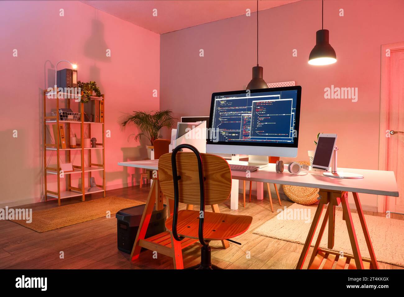 Programmer's workplace with devices in interior of dark office Stock ...
