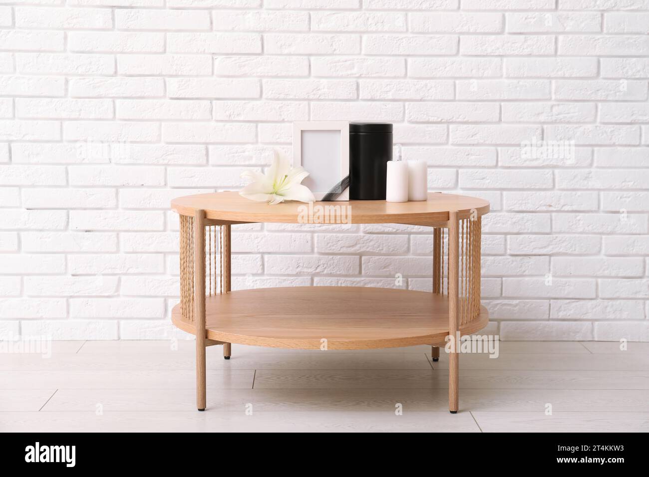 Blank funeral frame, mortuary urn, candles and lily flower on wooden ...