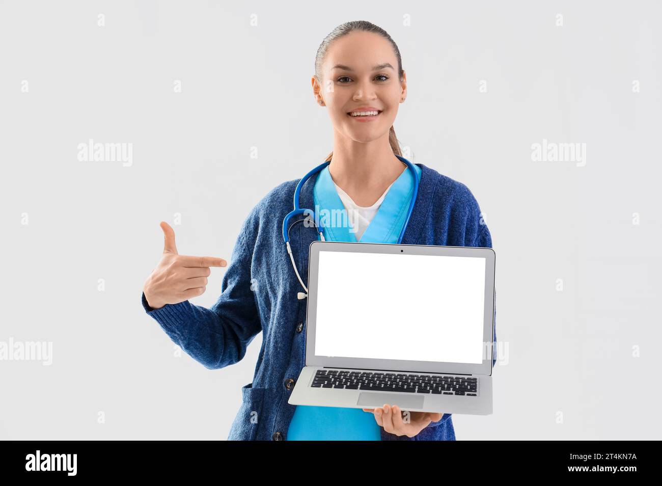Female medical intern pointing at laptop on white background Stock ...