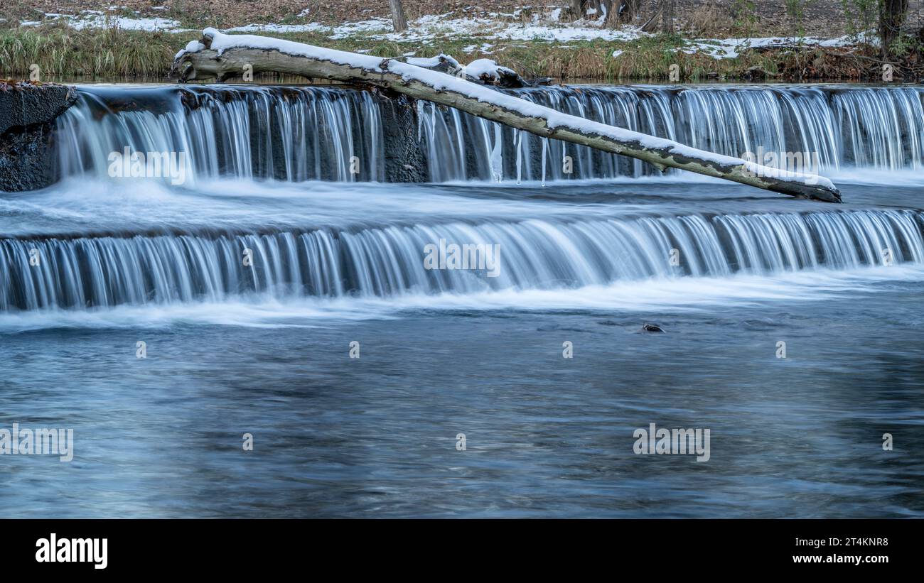 Water cascading over a diversion dam on the Poudre River with fall ...