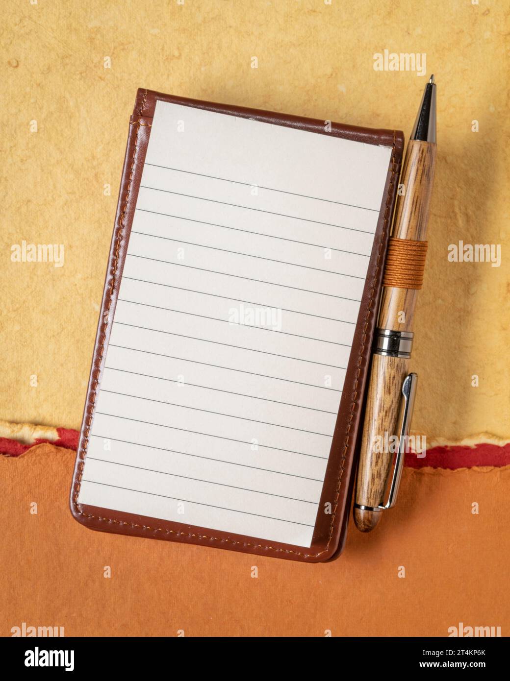 blank sheet of ruled paper in a small journal with a luxury pen against ...