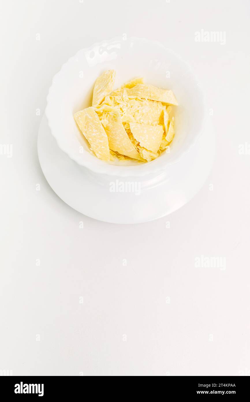 There are pieces of cocoa butter in a white plate. Close-up. Top view ...