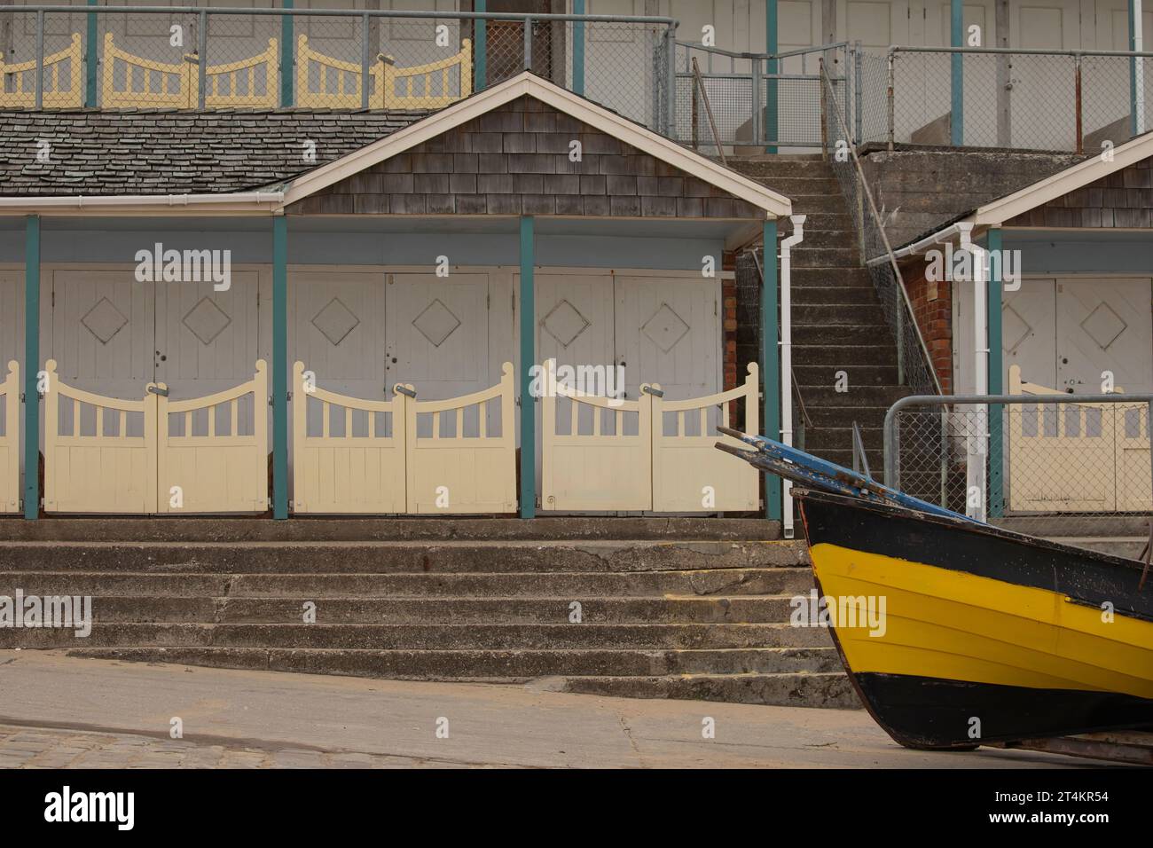 Private beach huts and a yellow boat with some steps going up Stock ...