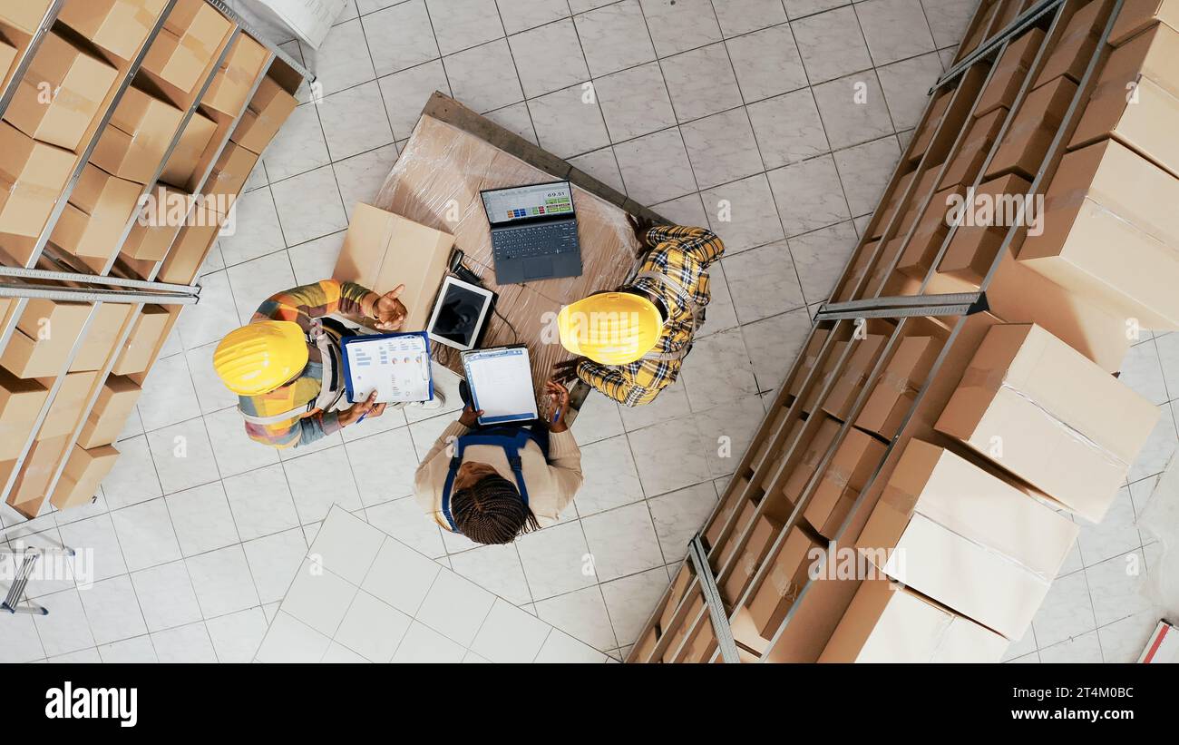 Storage room workers packing products in boxes, dping quality control ...