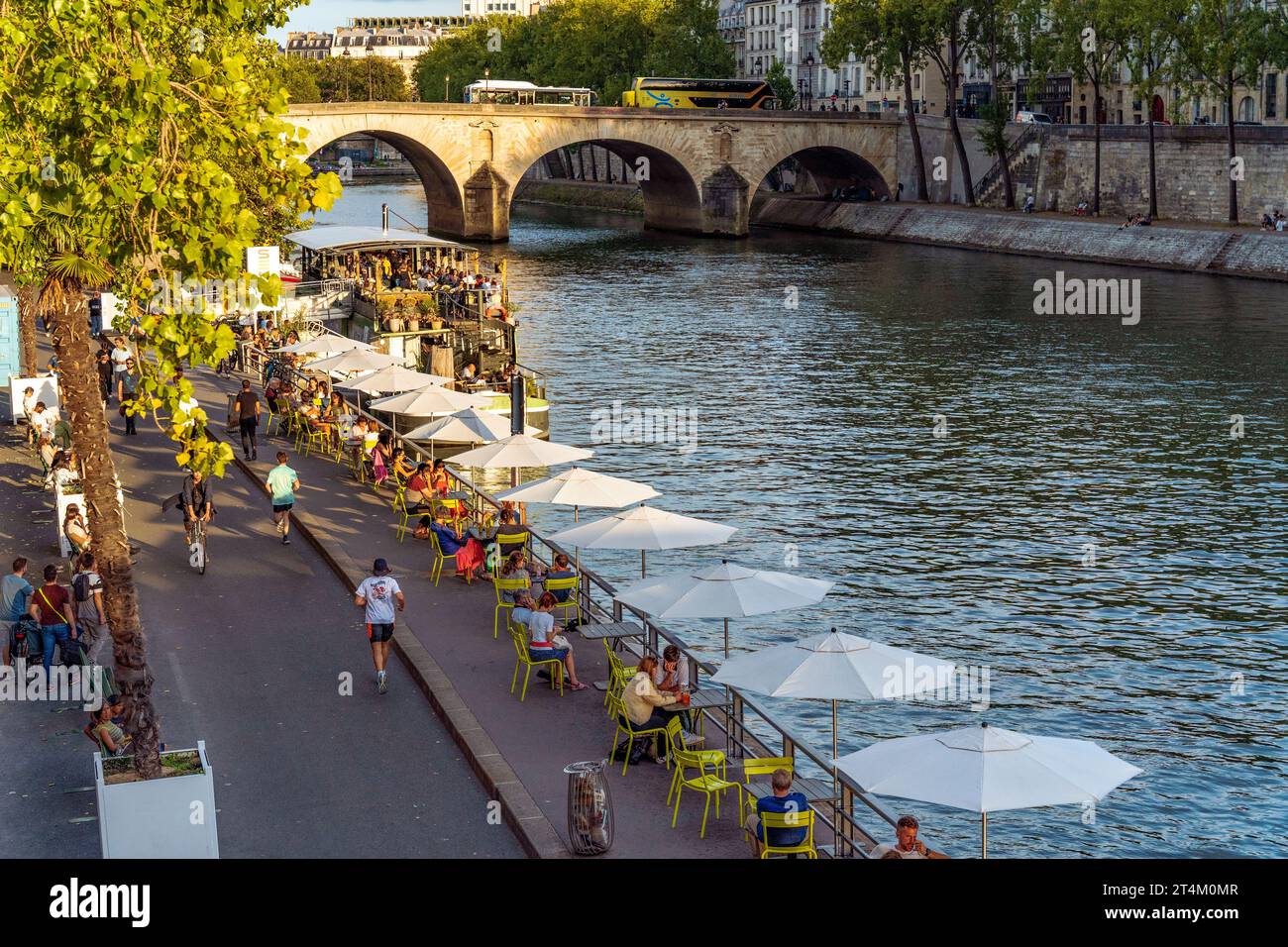 Lively quay along the Seine river with people enjoying time outside ...