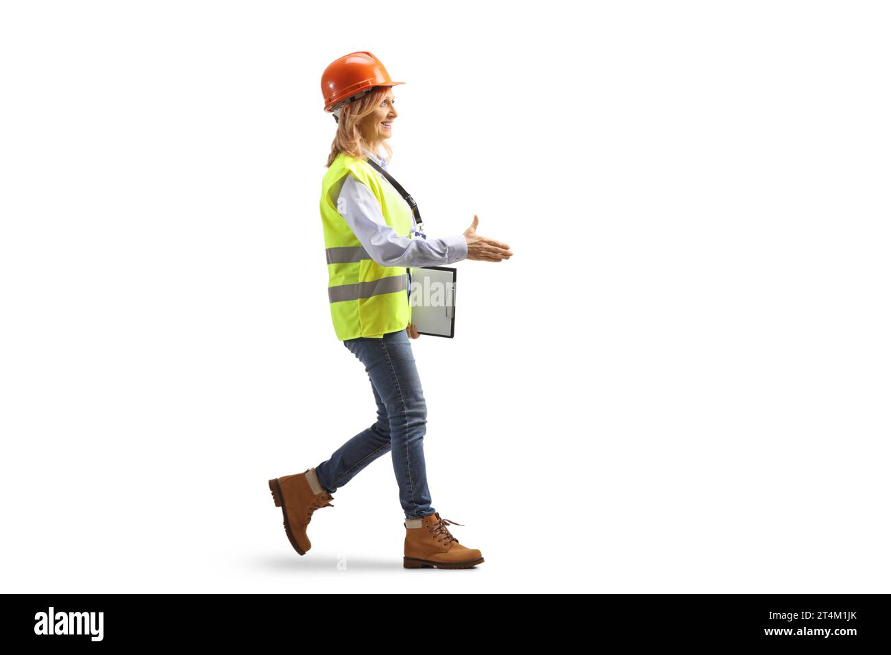 Full length profile shot of a female engineer walking and greeting with ...