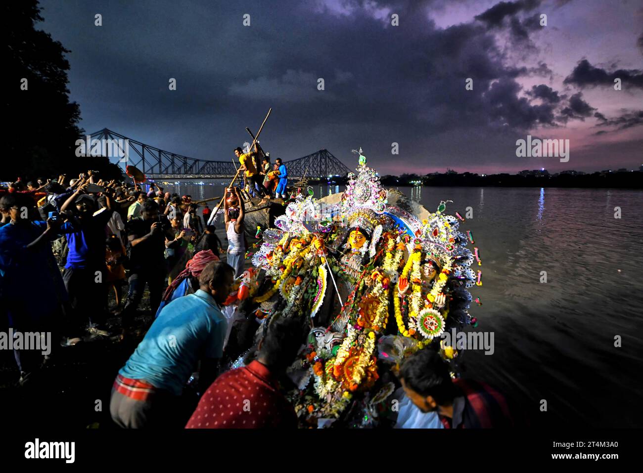 Hindu devotees submerge a clay idol of the Hindu goddess Durga in the ...