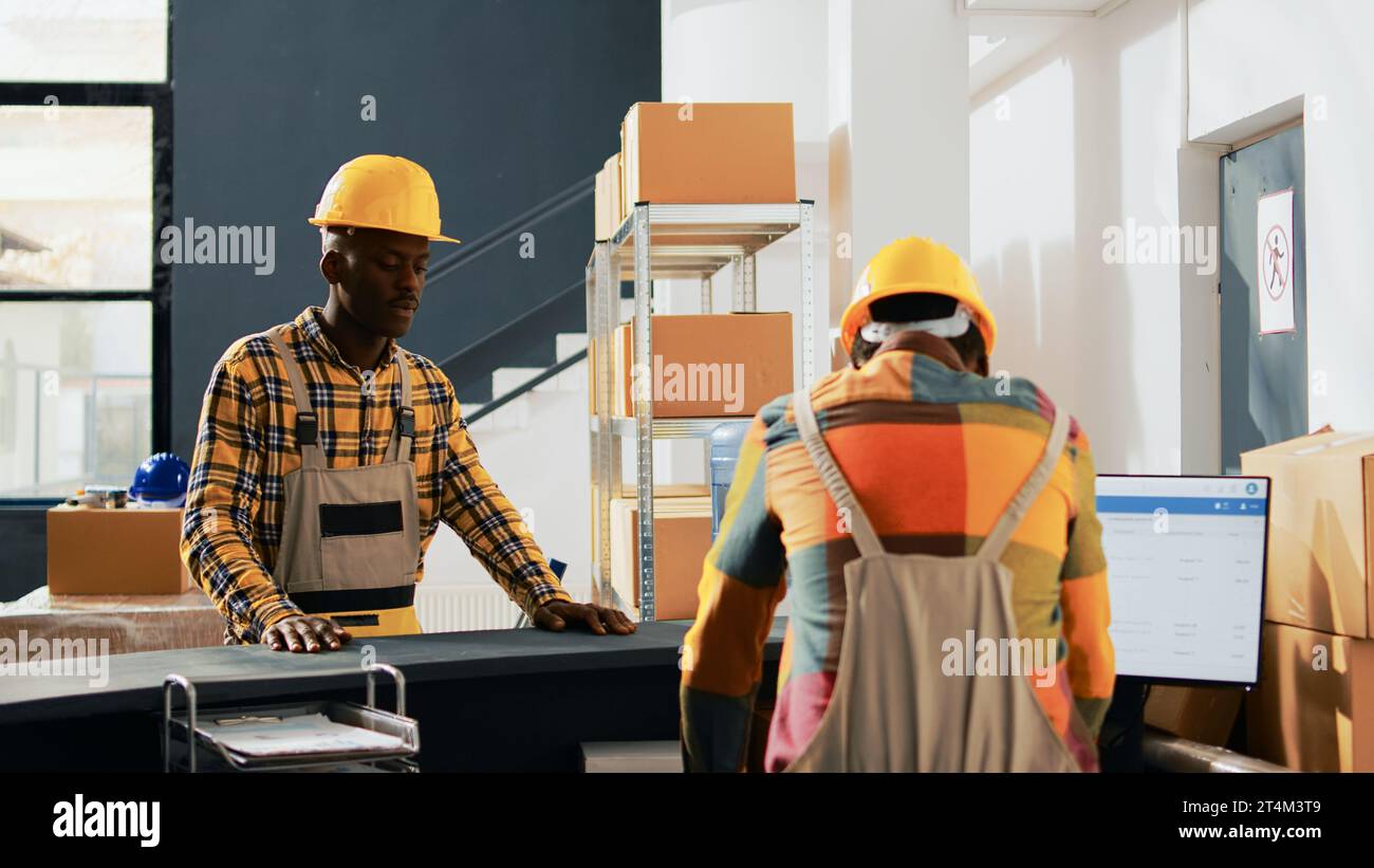African american employees doing fist bump gesture in warehouse ...