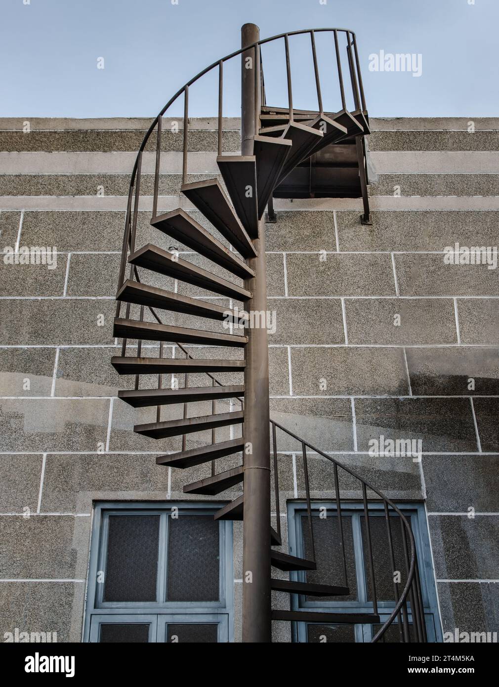 Brown metal spiral staircase with iron railing lead down from Rooftop ...