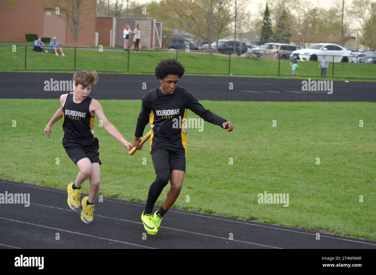 Two young men in a relay race passing the baton Stock Photo - Alamy