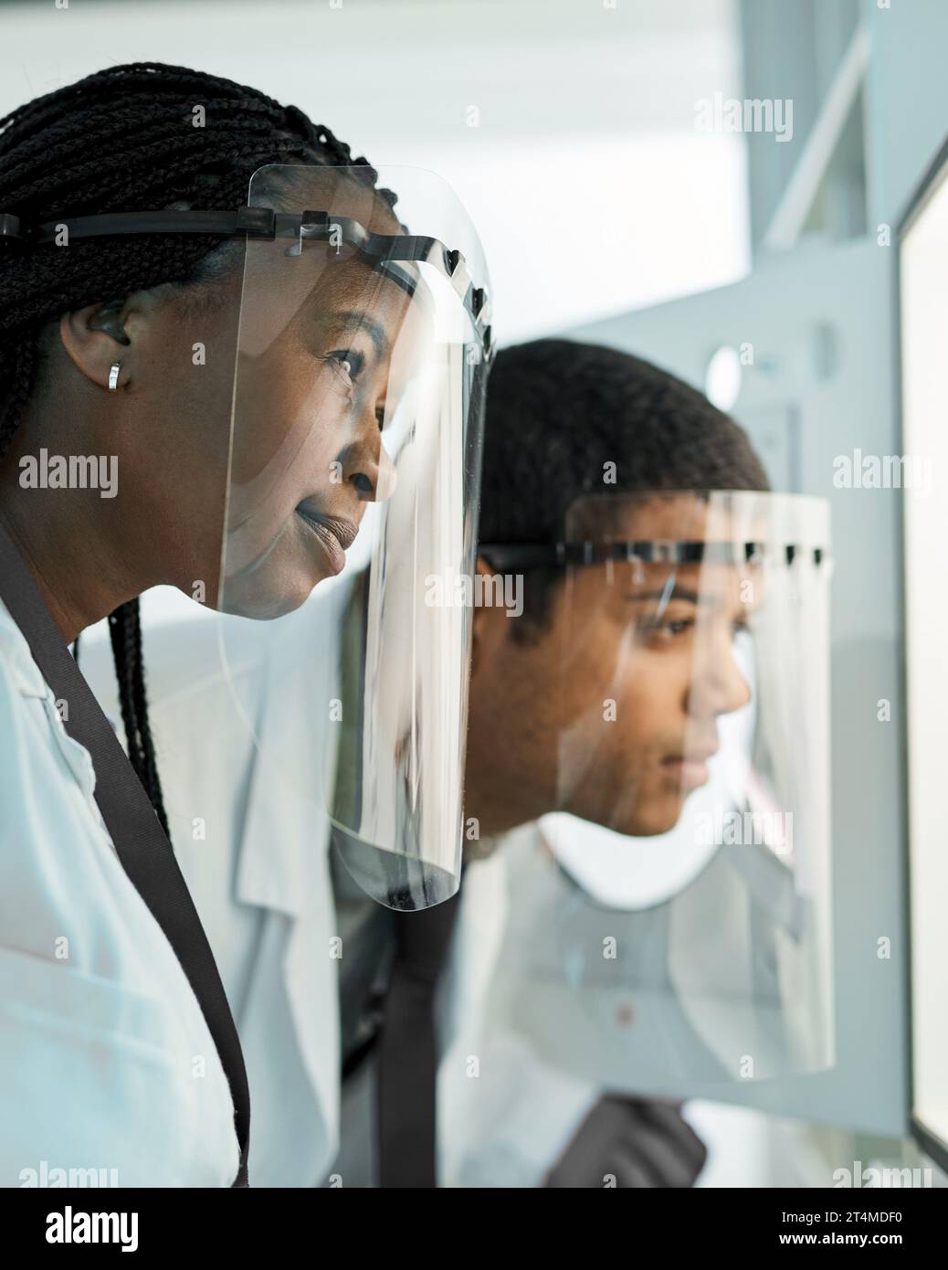 Applying their great minds. two scientists wearing face shields while ...