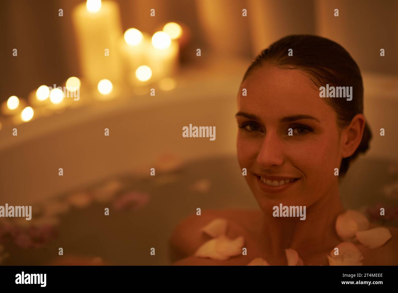 Finding tranquility in a rose water bath. a gorgeous woman relaxing in ...