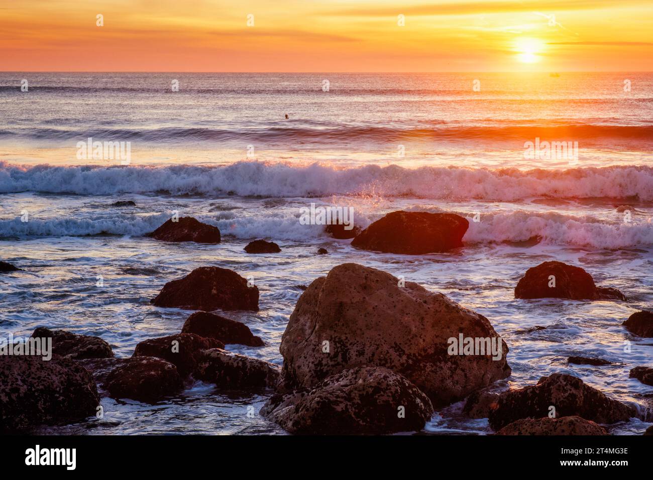Atlantic ocean sunset with waves and rocks at Costa da Caparica ...