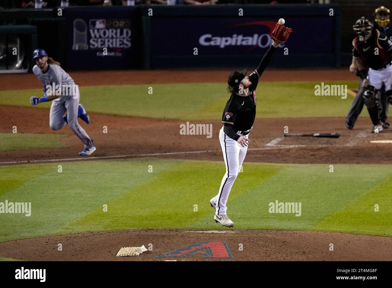 Arizona Diamondbacks pitcher Ryne Nelson, right, fields a ground ball by Texas Rangers' Travis ...